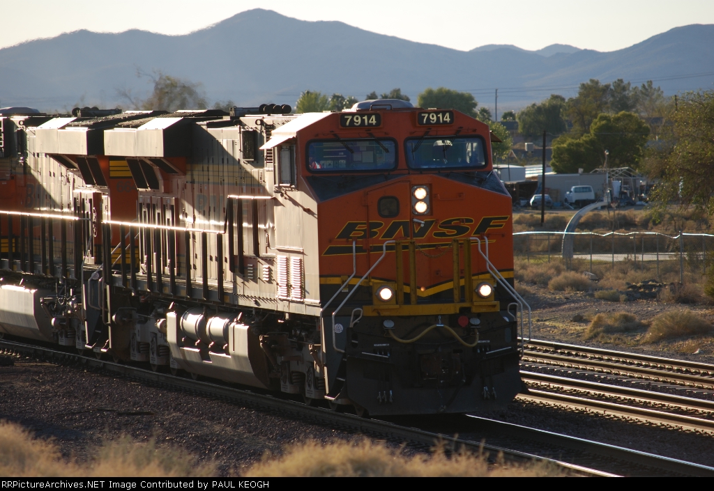 BNSF 7914 with BNSF 6644 behind her roll eastbound with a Bear Table (Empty spine car load ...